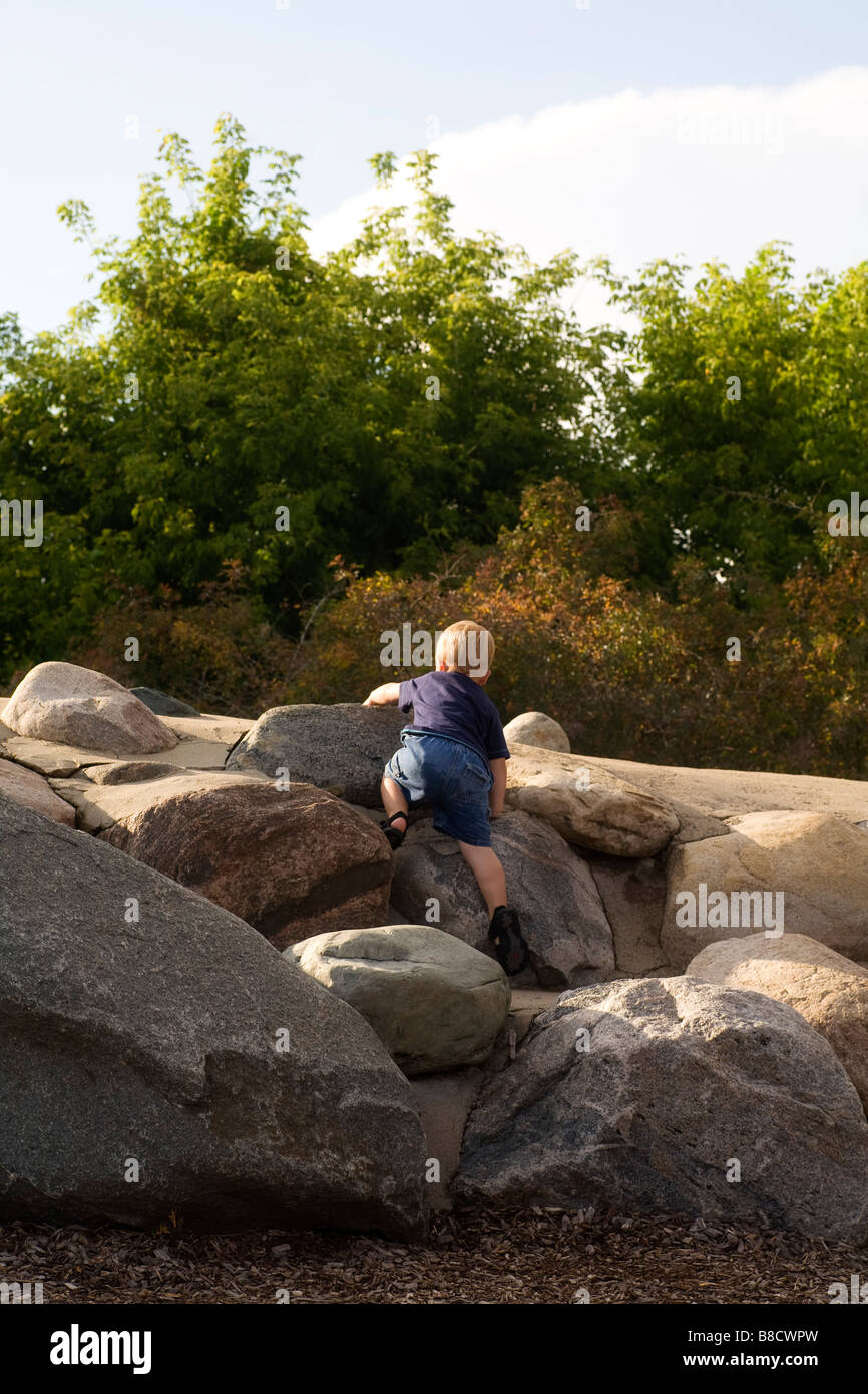 Boy crawling on rocks Stock Photo - Alamy