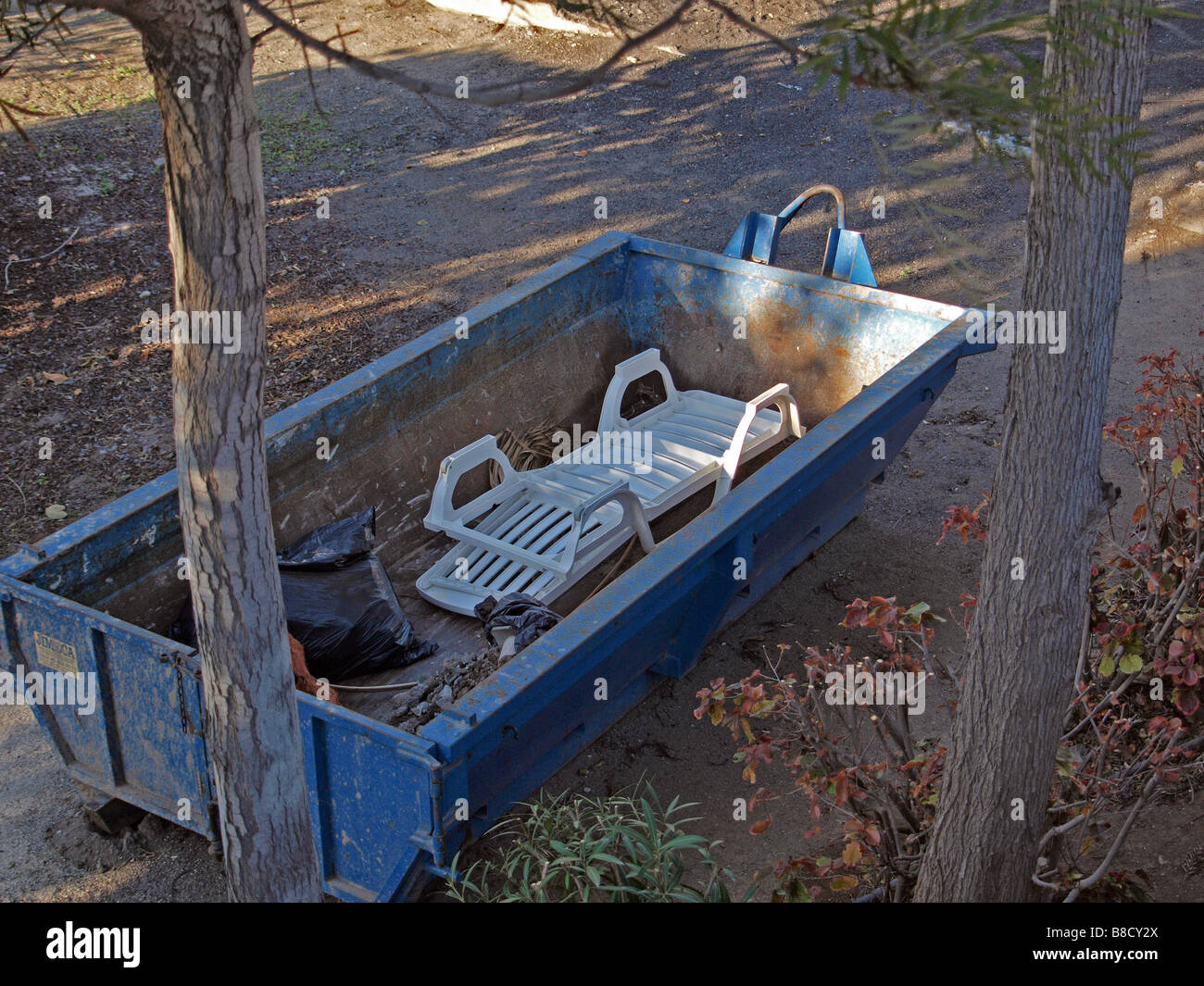 Broken plastic sub bed in a blue skip Stock Photo - Alamy
