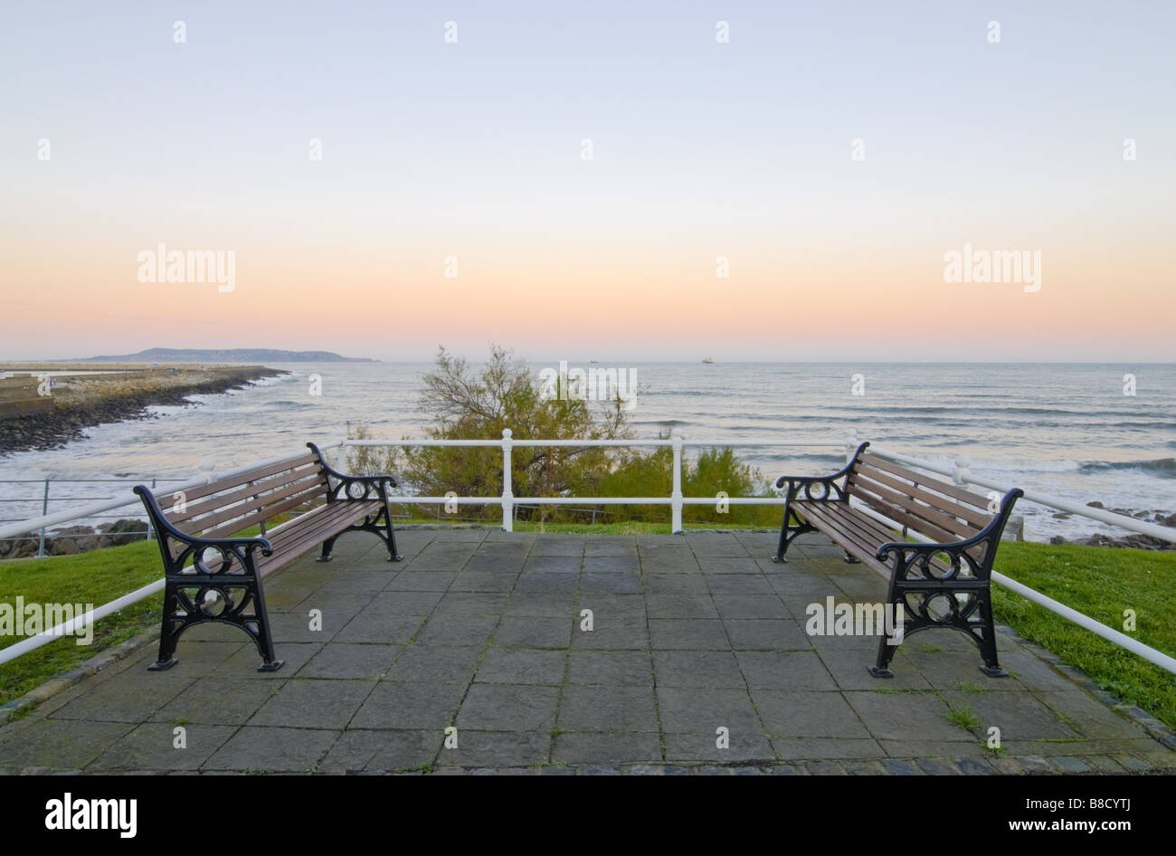 Two benches at Dun Laoghaire harbour overlooking Dublin Bay Stock Photo ...