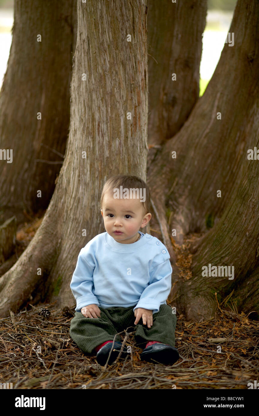 Baby Boy Sitting Under Trees Stock Photo - Alamy