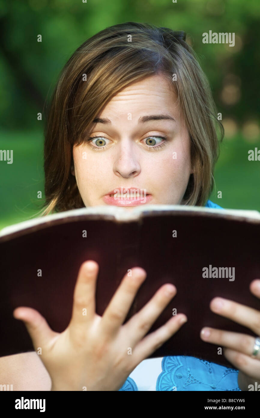 Shocked woman reading book Stock Photo - Alamy