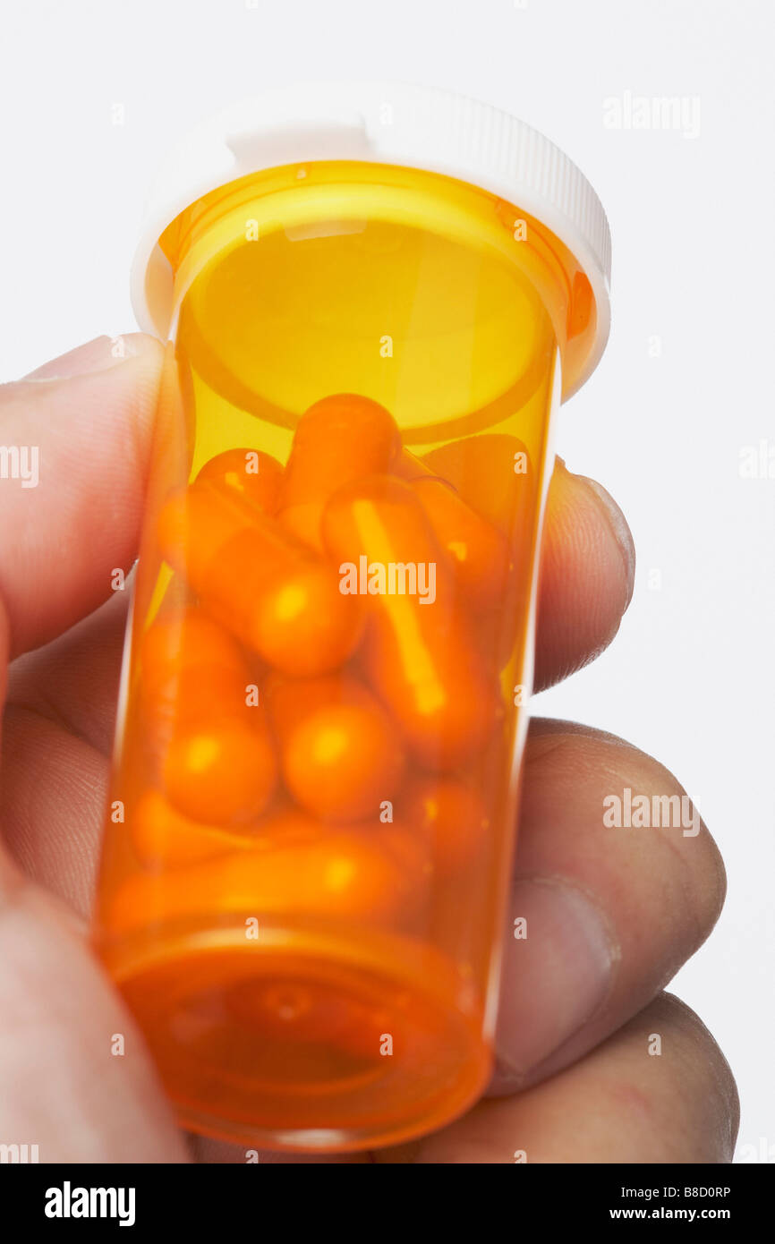 Hand holding Full Pill Bottle Stock Photo - Alamy