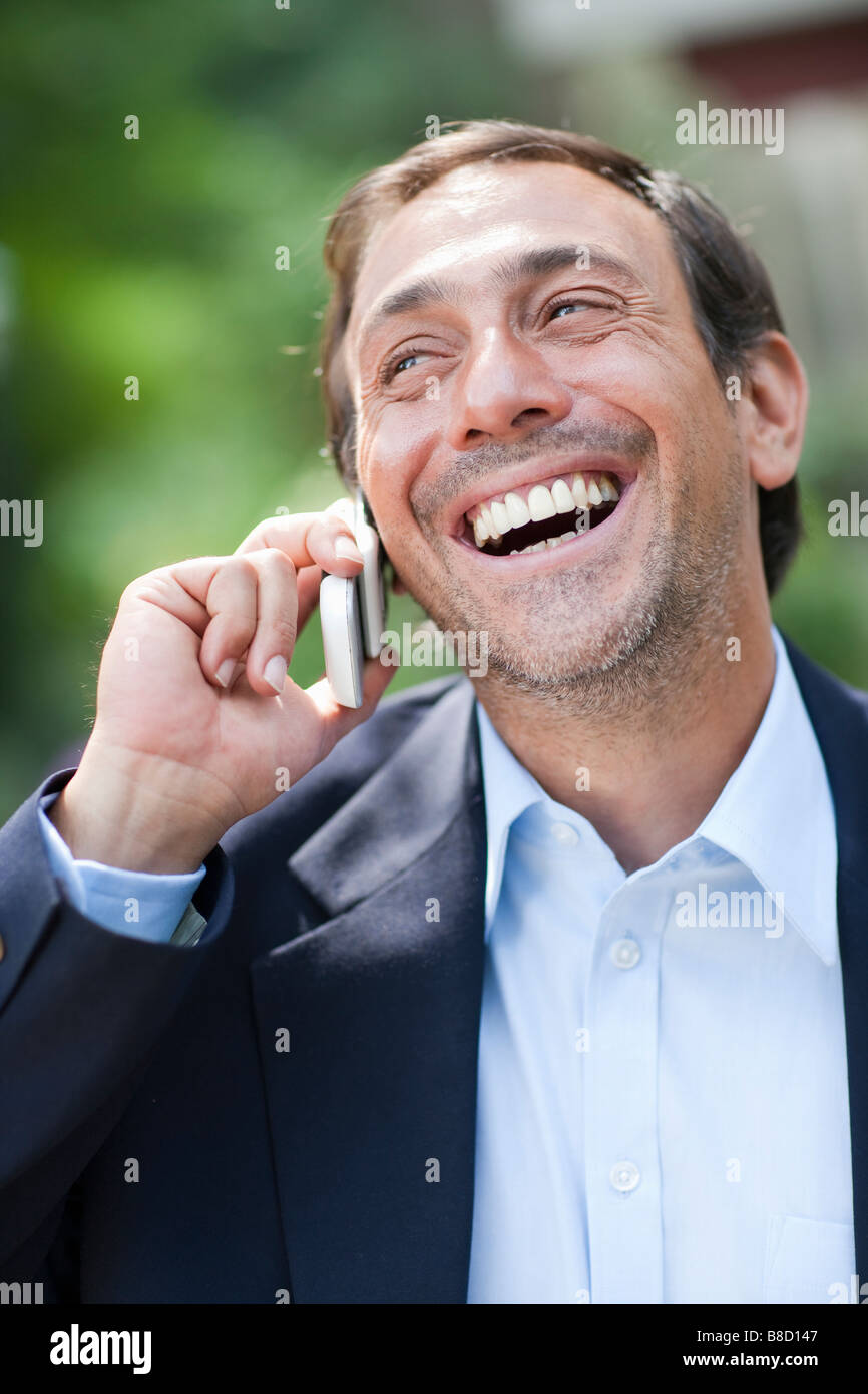 Laughing man talking on his cell phone outside Stock Photo - Alamy