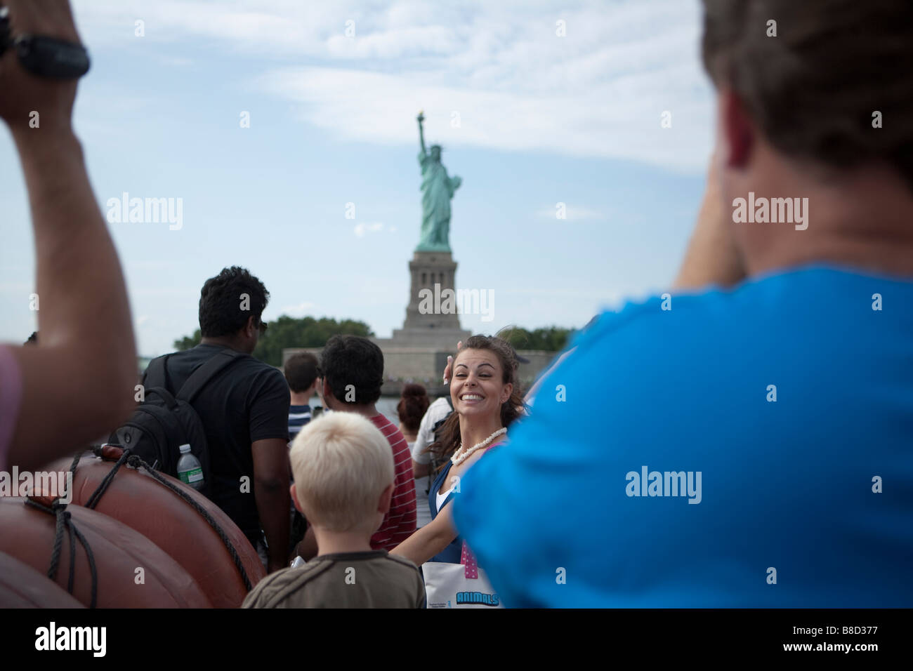 crowd of tourists near the statue of liberty visiting and takeing ...