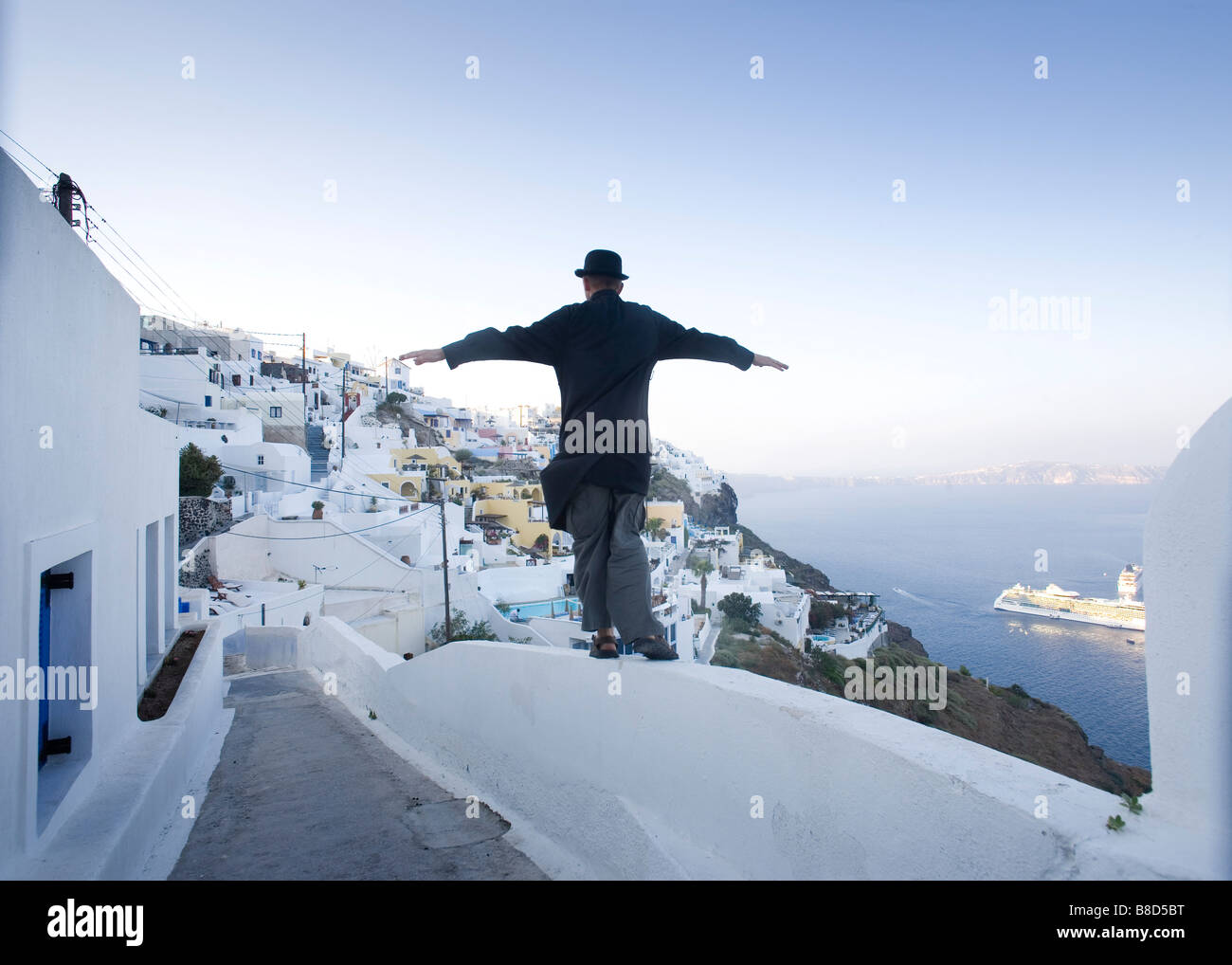 Man Balancing Wall Coat Hat, Santorini, Greece Stock Photo - Alamy