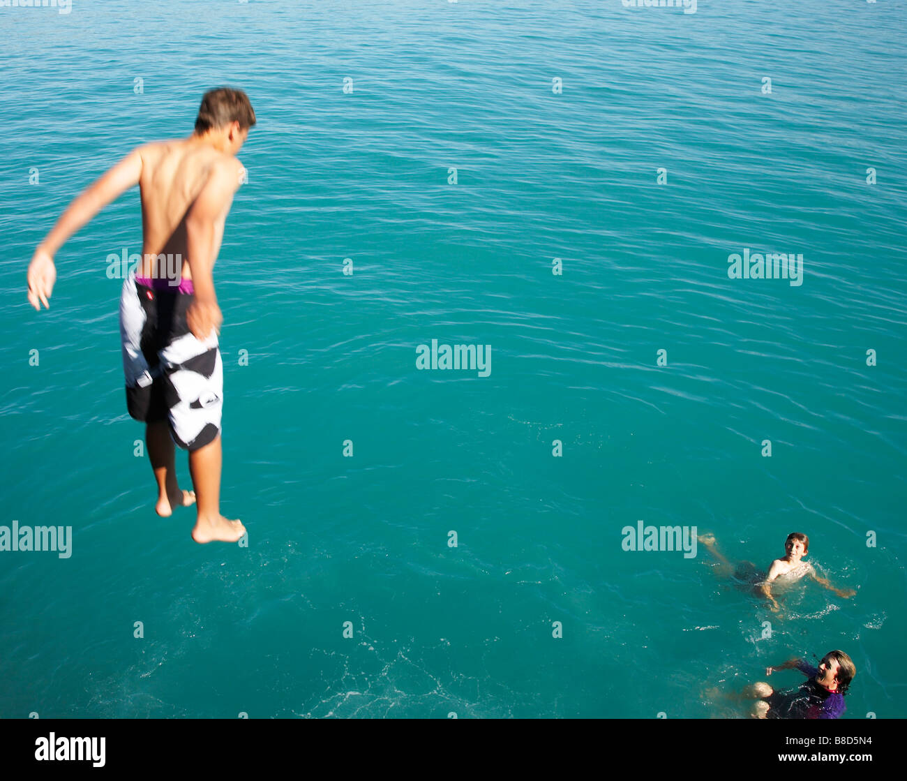 children 14 jumping of wharf into sea Stock Photo - Alamy