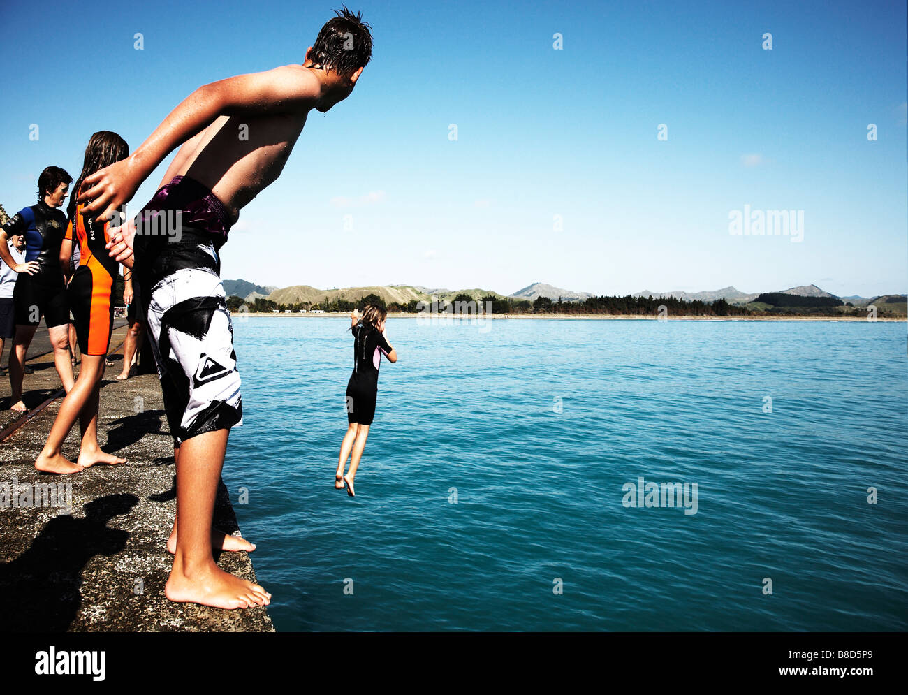 children 14 jumping of wharf into sea Stock Photo - Alamy