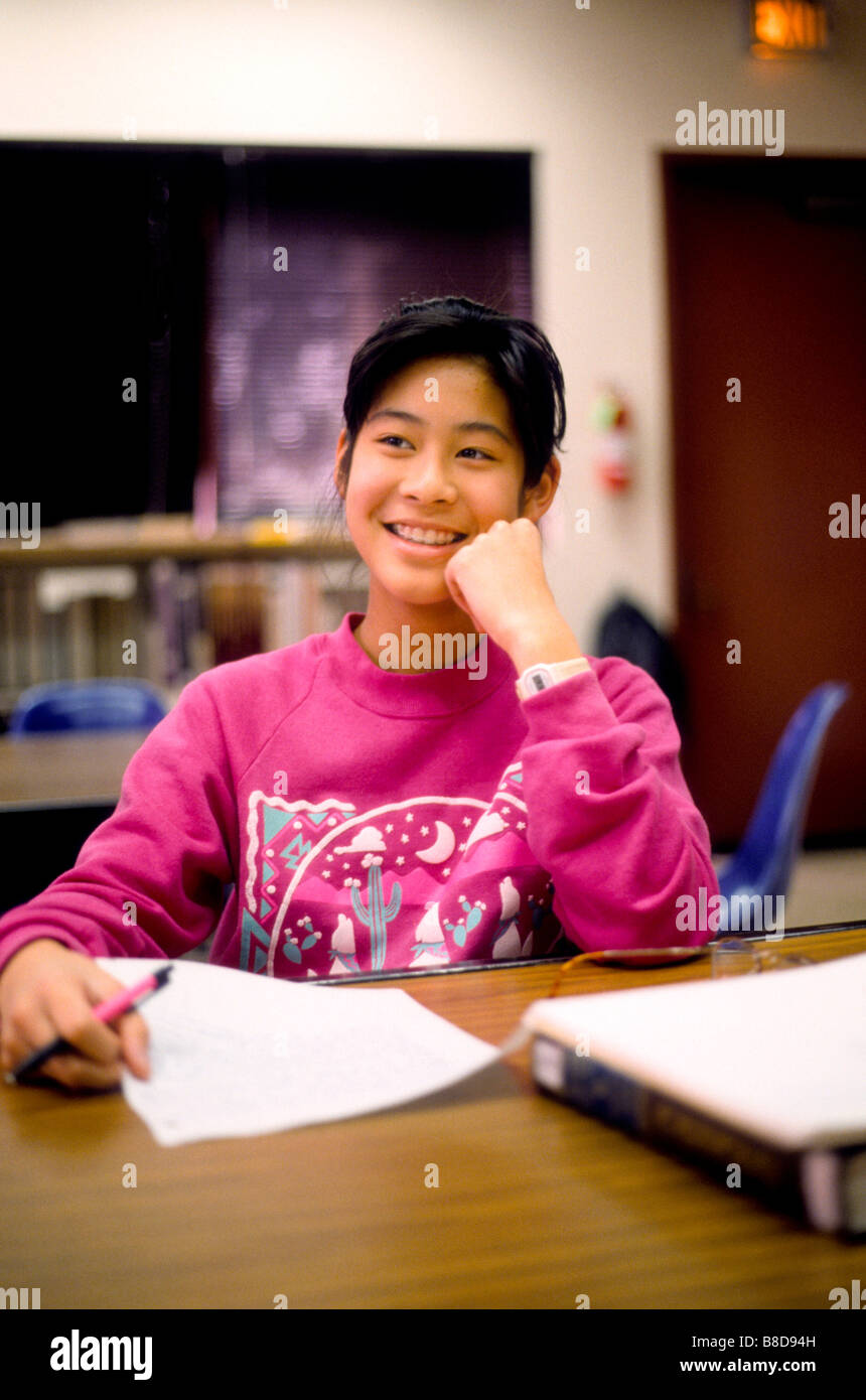 Asian-American girl smiles as she works in school classroom Stock Photo ...