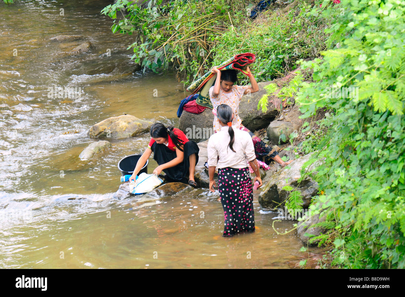 Refugee girls is washing thier clothes and stuffs in the river outside ...