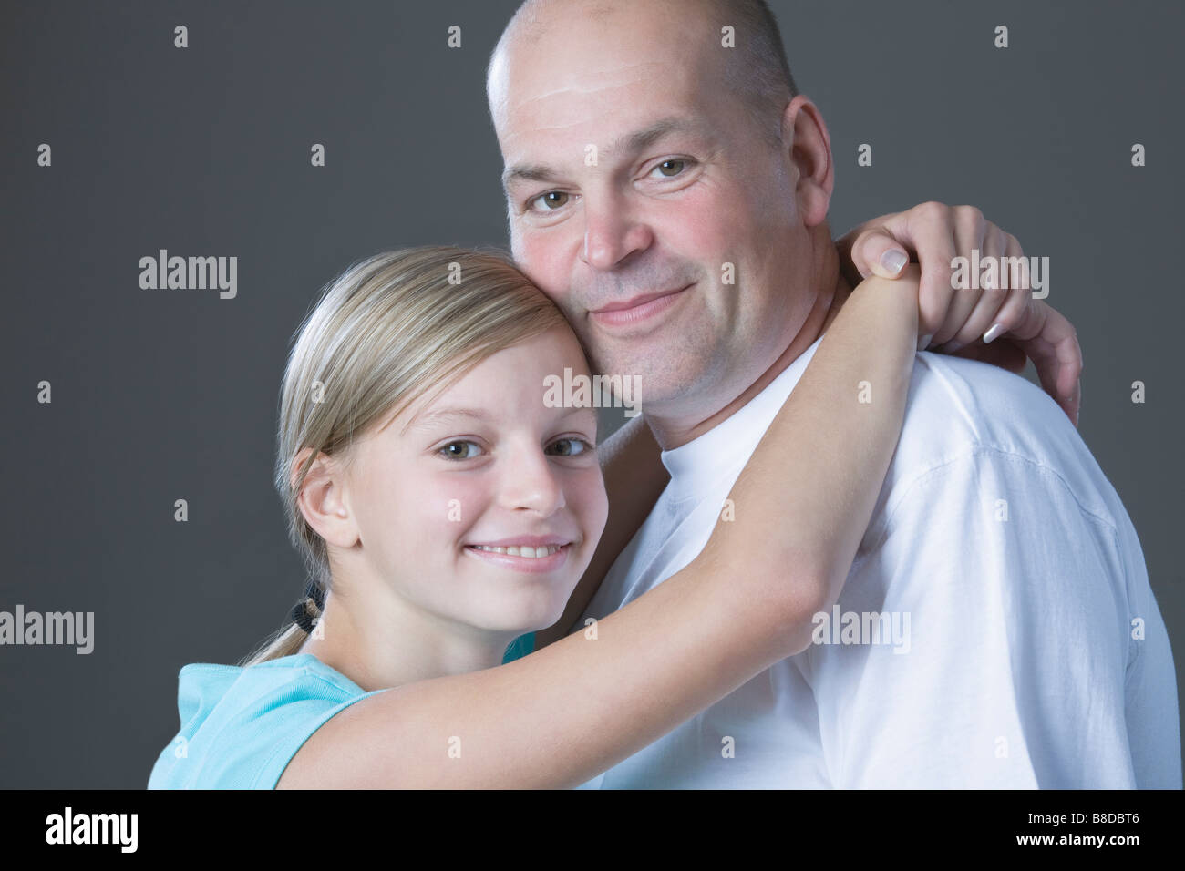 Studio portrait of daughter embracing father Stock Photo - Alamy