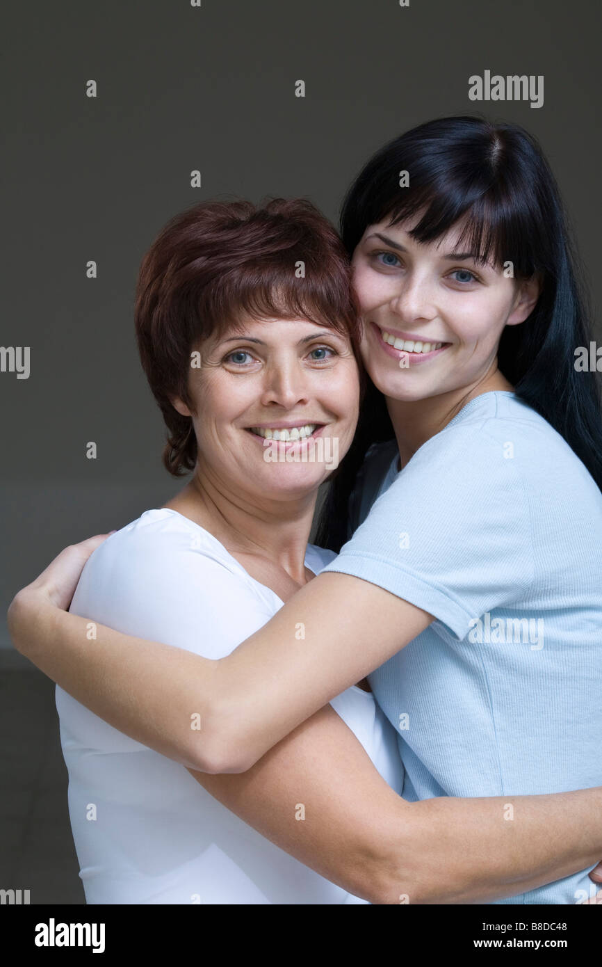 Studio portrait of young woman embracing mother Stock Photo - Alamy