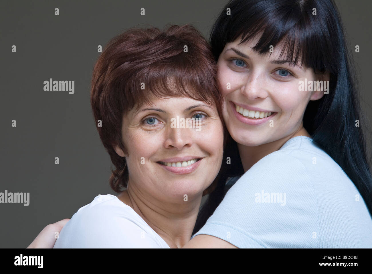Studio portrait of young woman embracing mother Stock Photo - Alamy