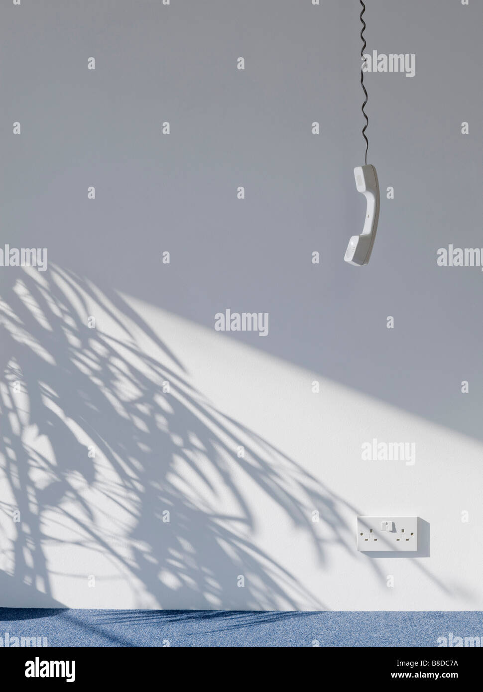 Telephone receiver hanging in empty room Stock Photo - Alamy