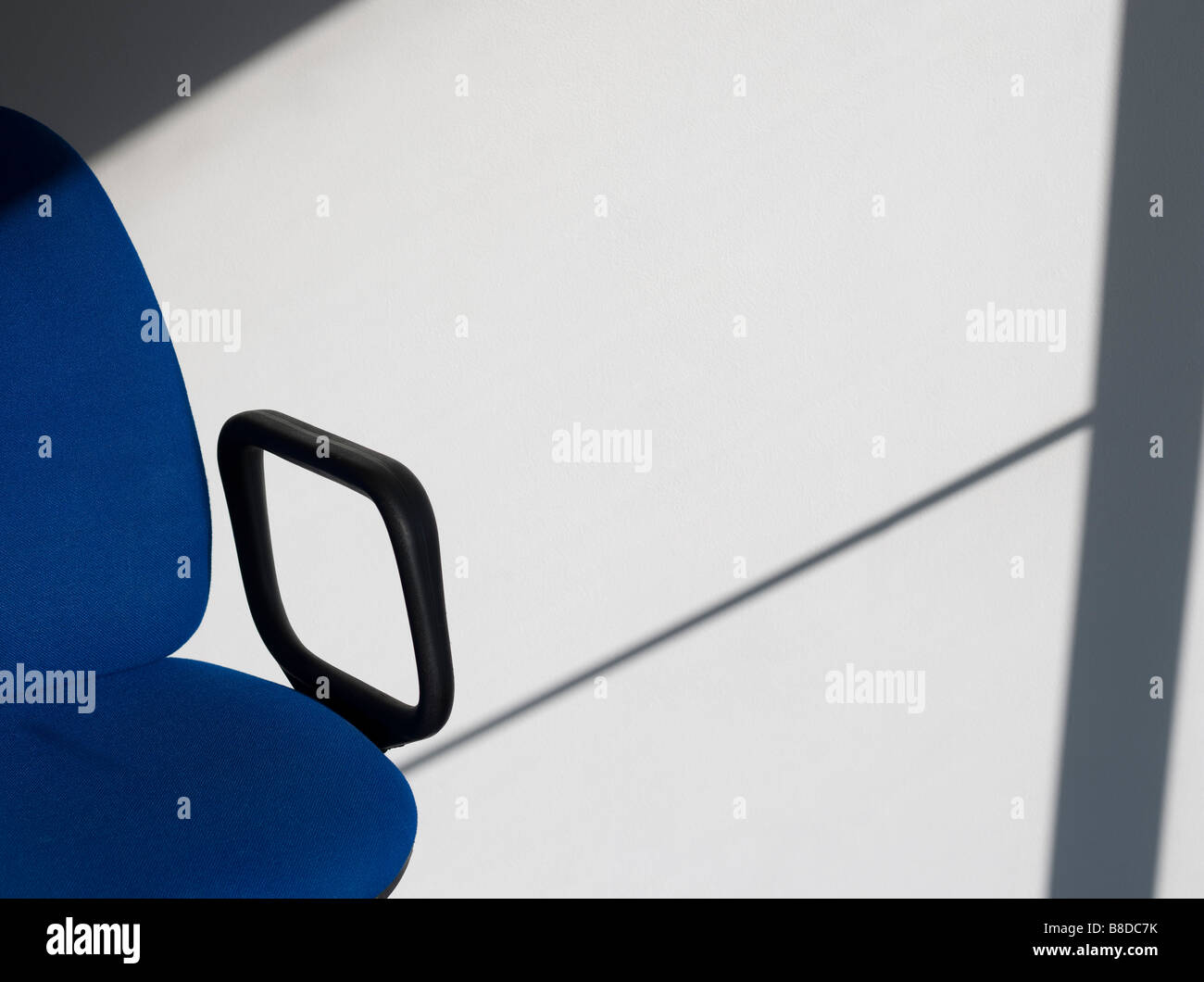 Office chair casting shadow on wall Stock Photo - Alamy