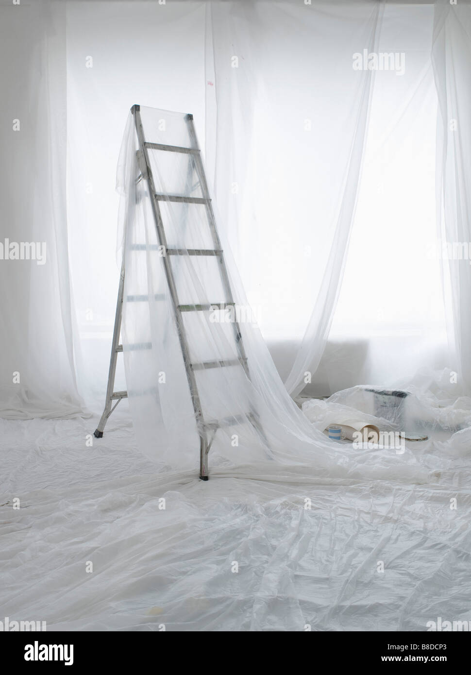 Empty room covered in transparent dust sheets prepared for painting and ...