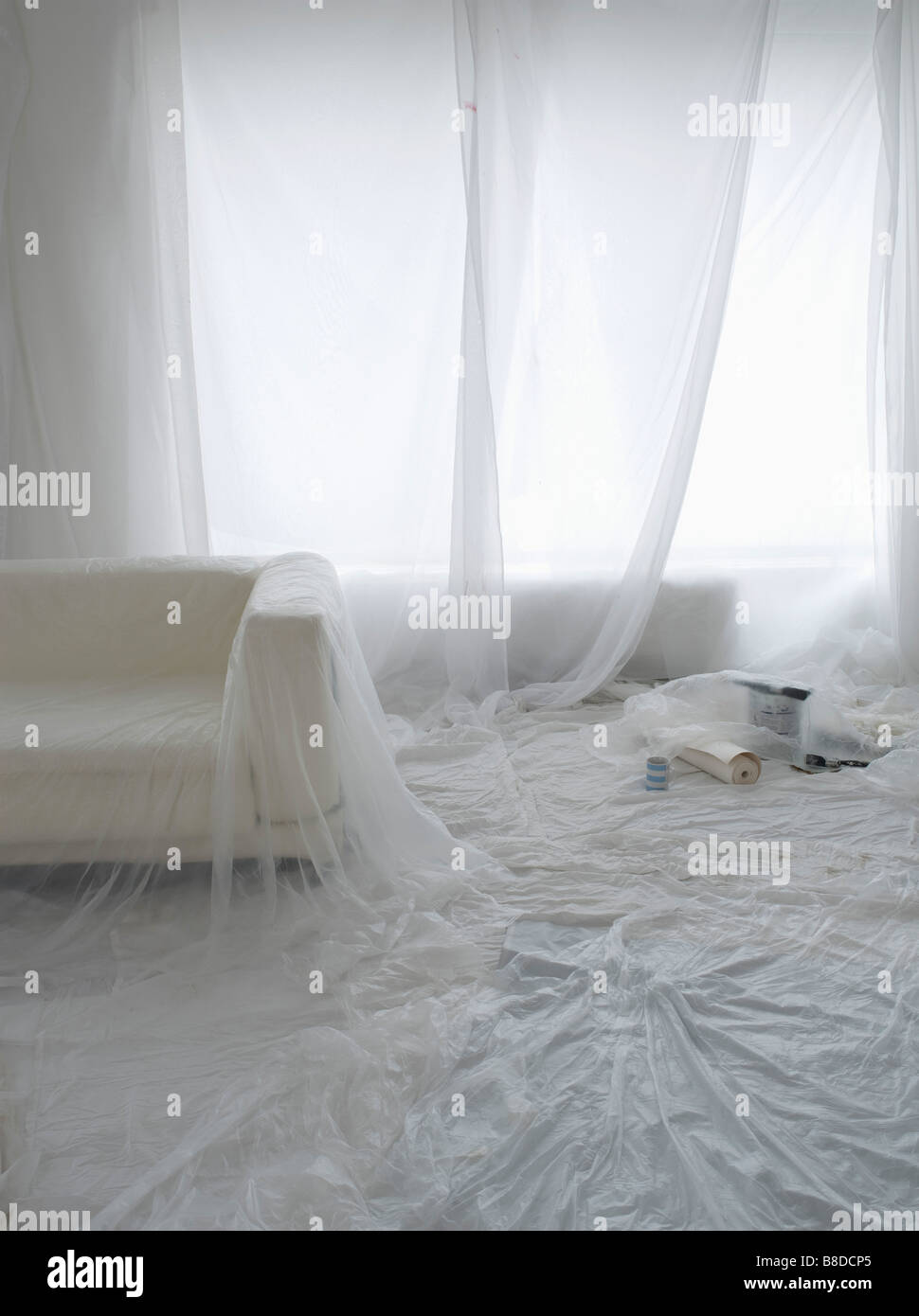 Room covered in transparent dust sheets in preparation for decorating ...