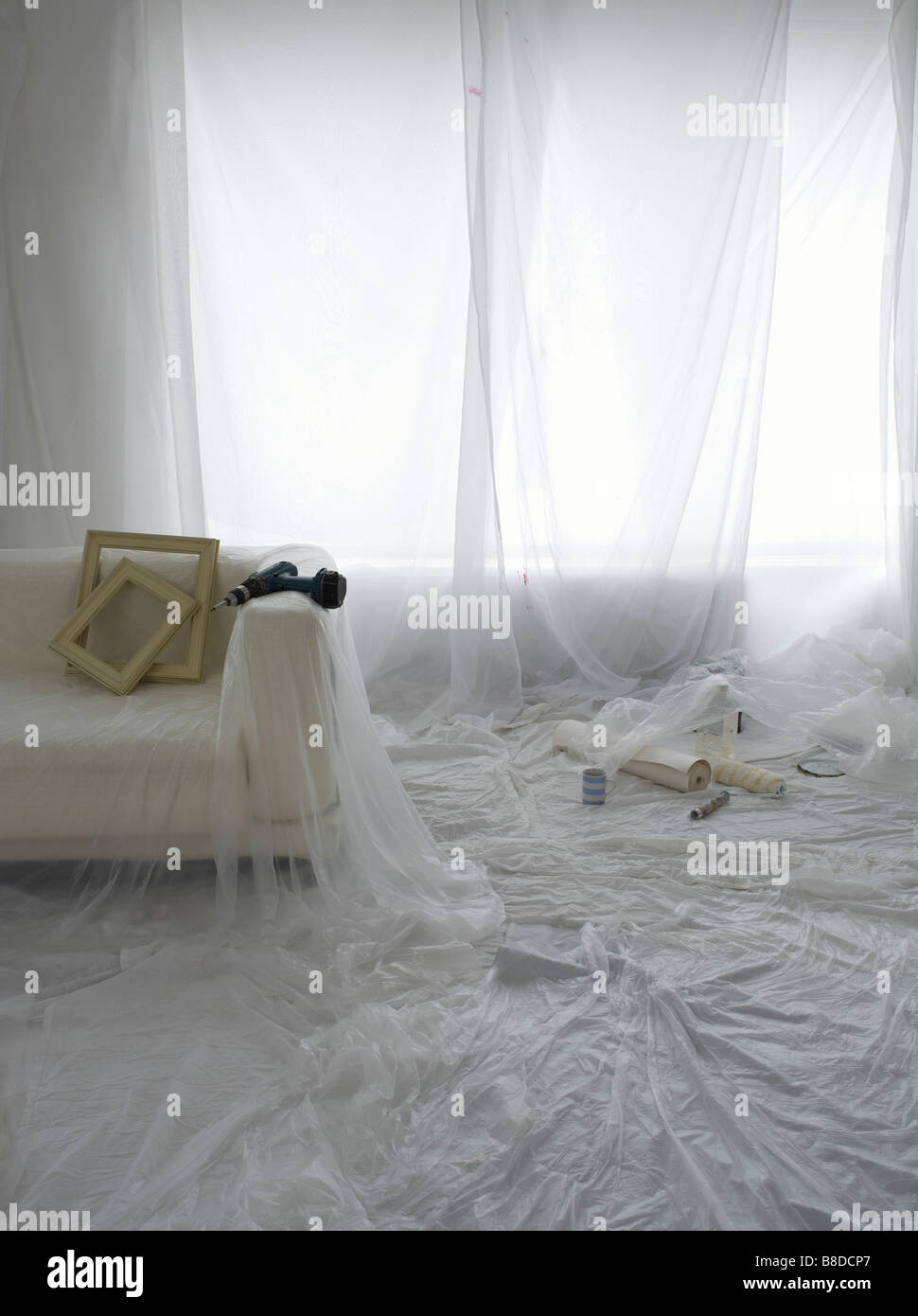 Room covered in transparent dust sheets in preparation for decorating ...