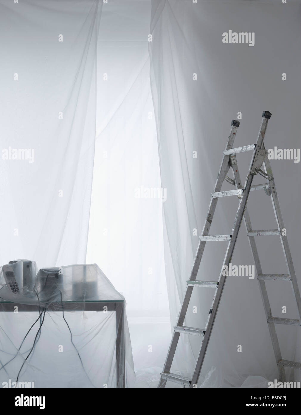 Desk with phones and cables covered in transparent dust sheets with ...