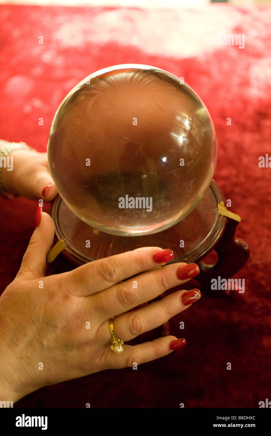 Clairvoyant with hands round a crystal ball Stock Photo - Alamy