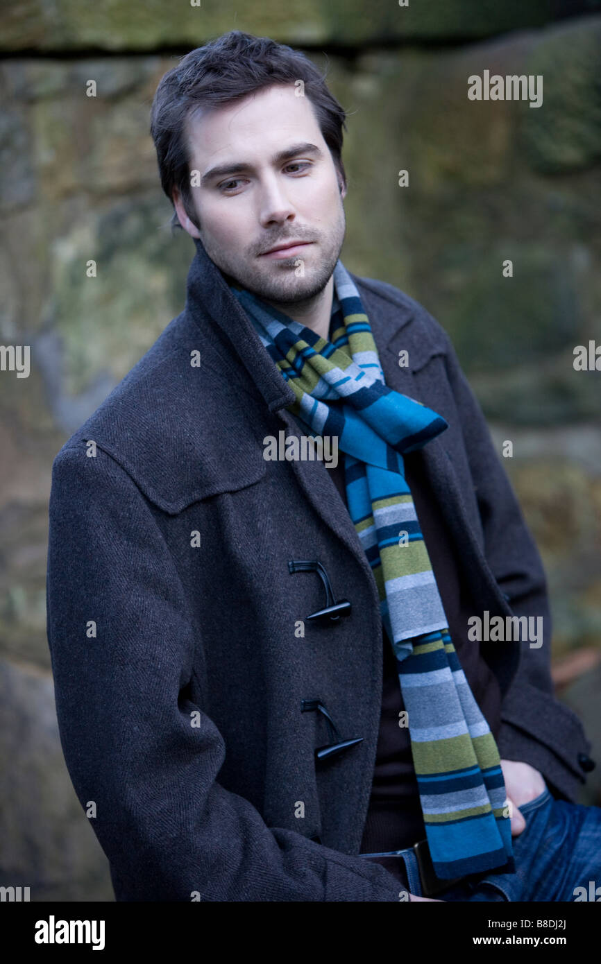 attractive male in winter wearing wooly scarf and coat looking at ...