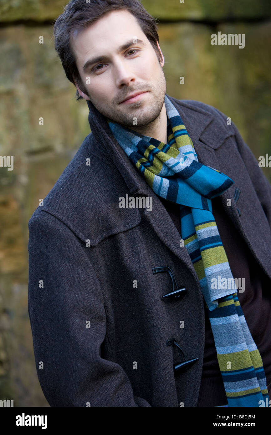 attractive male in winter wearing wooly scarf and coat looking at ...