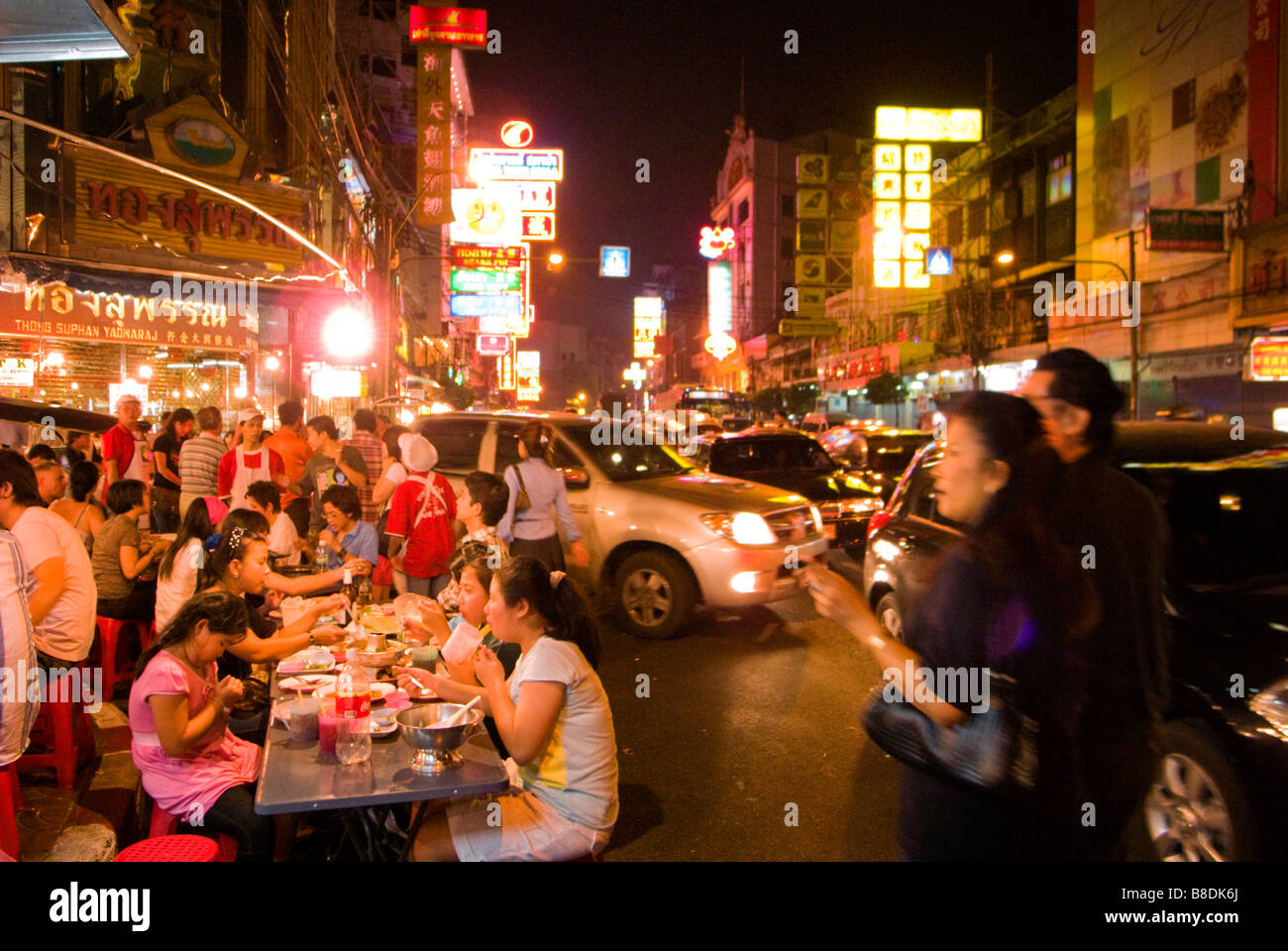 People eating at busy street corner restaurant near heavy traffic ...