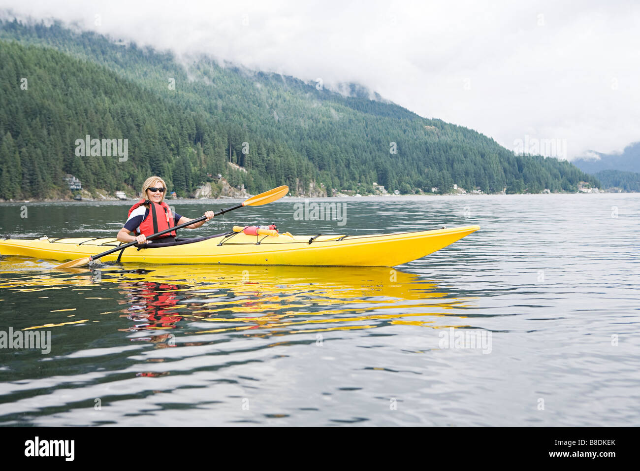 Woman kayaking in fjord Stock Photo - Alamy