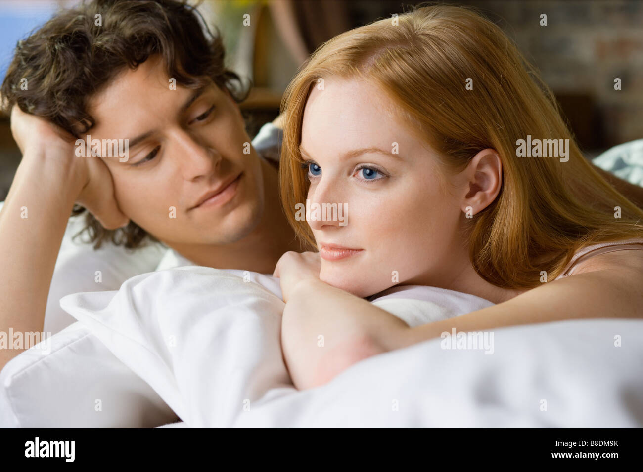 Couple relaxing in bed Stock Photo - Alamy