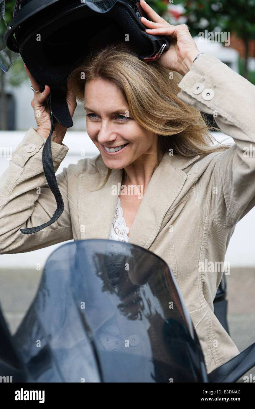 Female motorcyclist removing her helmet Stock Photo - Alamy