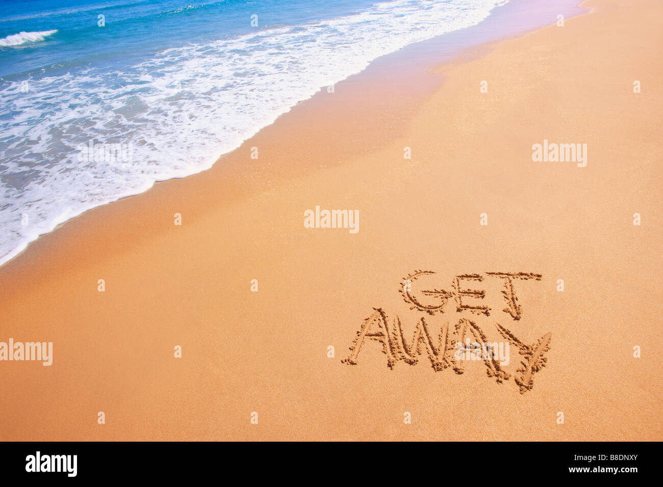 Get away written in the sand Stock Photo - Alamy
