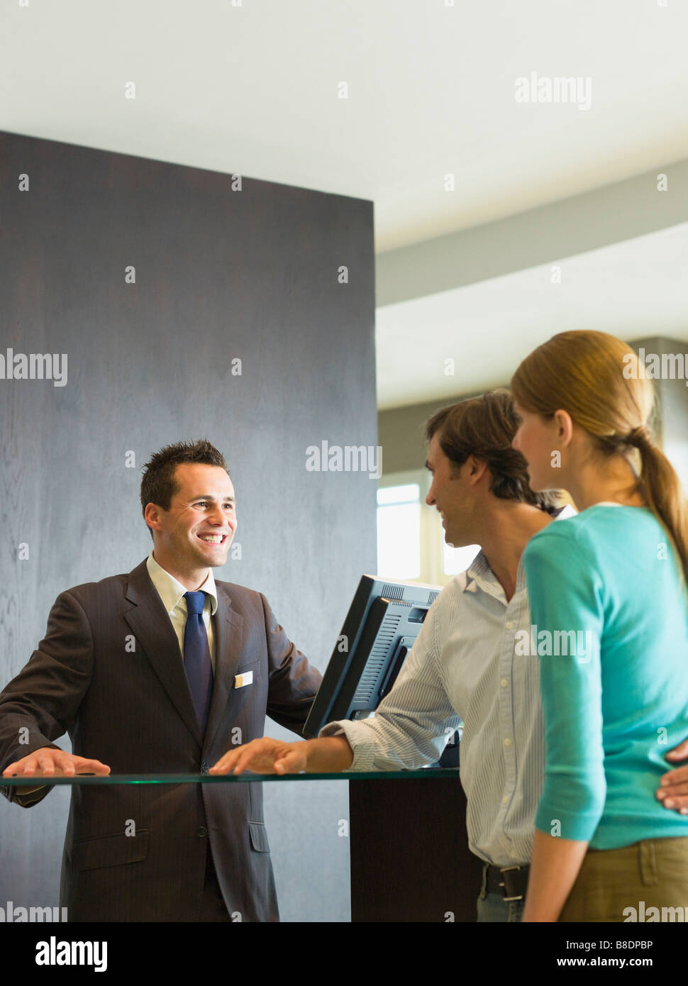 Couple checking into a hotel Stock Photo - Alamy