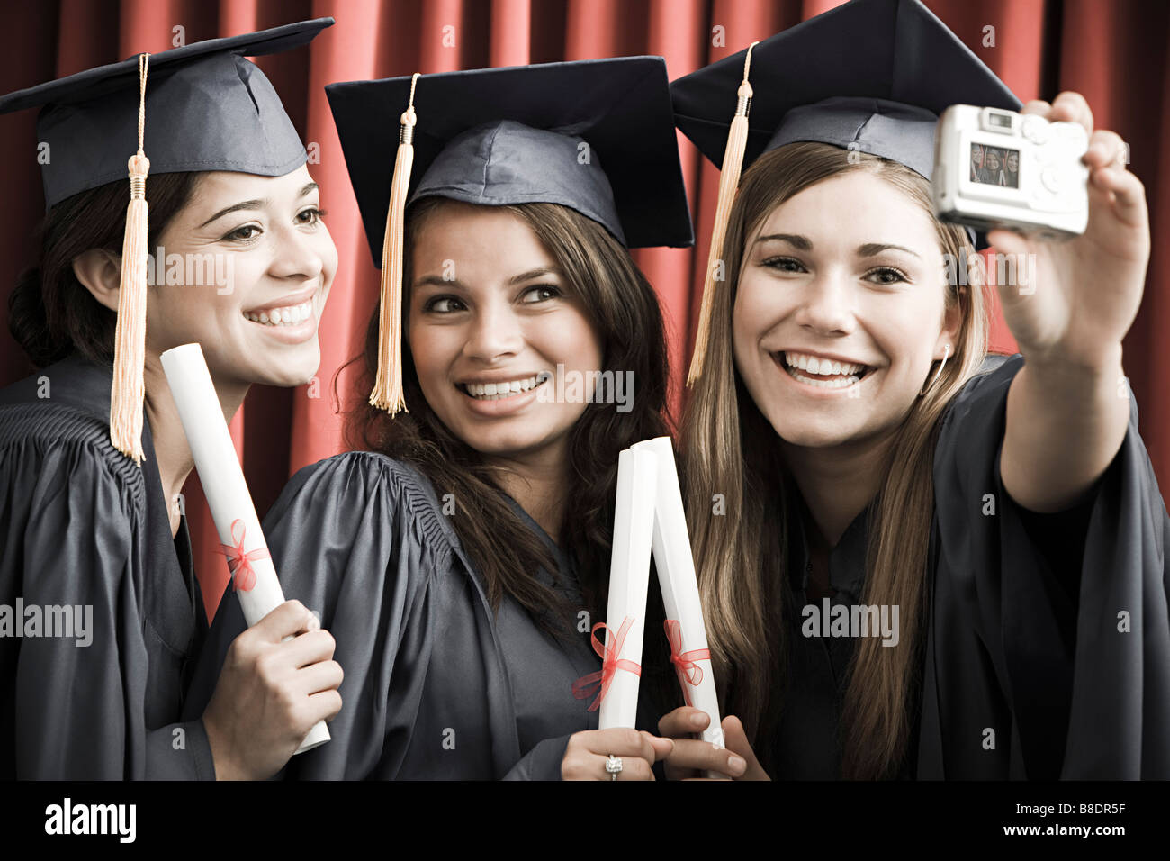Graduating friends with camera Stock Photo - Alamy