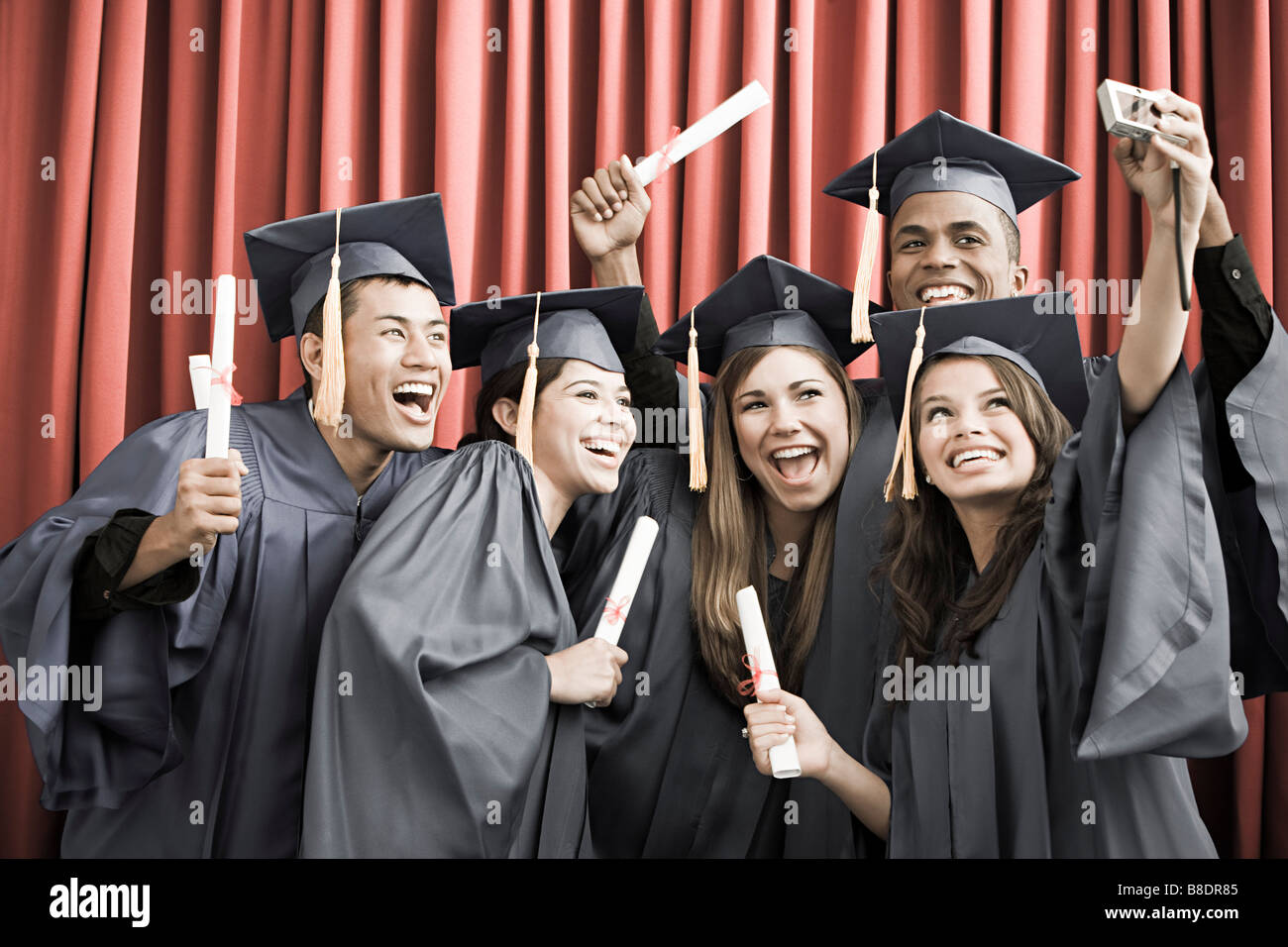 Graduating friends with camera Stock Photo - Alamy