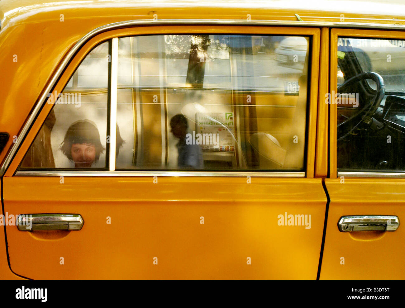 A yellow cab window with a reflection of a woman on a advertising ...