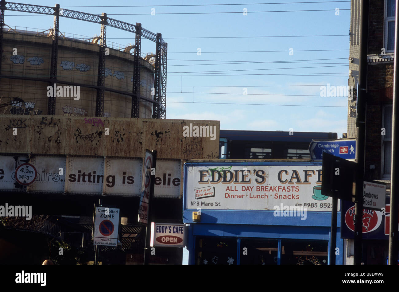 Shop signs on East End street, Hackney London with gas tower and ...