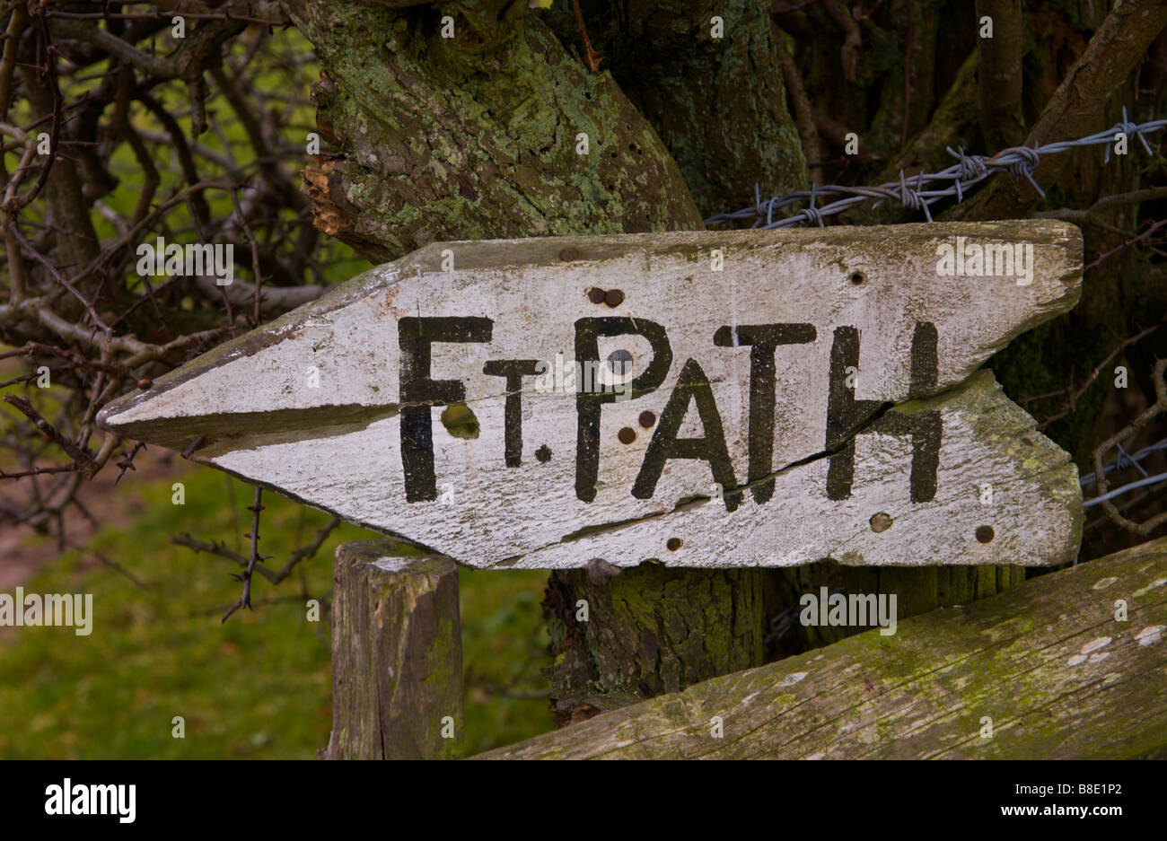 Homemade footpath direction sign fixed to stile on hillside track above ...