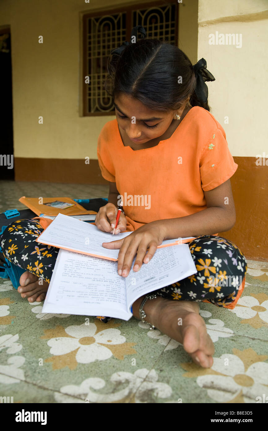 Schoolgirl doing her homework in her school exercise book. Hazira ...