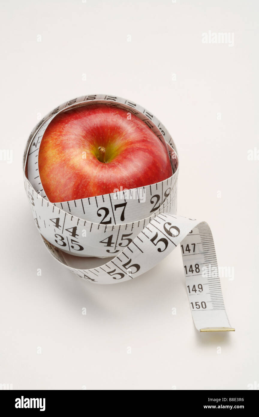 Close up of an apple twisted by a tape measure Stock Photo - Alamy