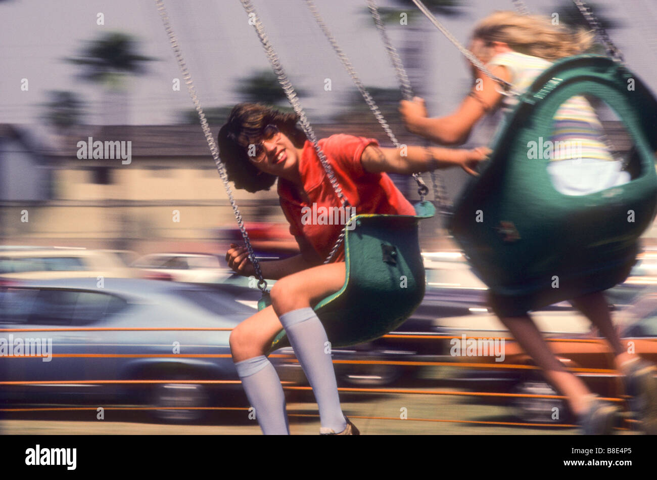 Girls ride on carnival swing ride at county fair Stock Photo - Alamy