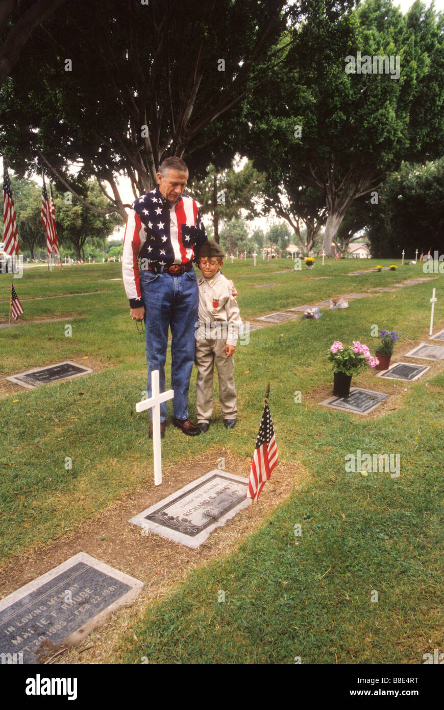 Grandfather and grandson pause to remember family members in cemetery ...
