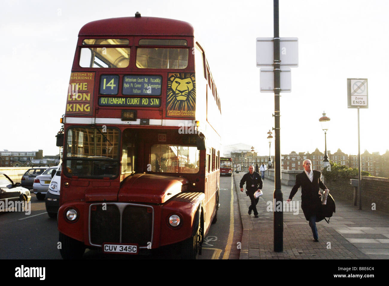 Two men running form a Routemaster bus, trying to jump on the bus in ...