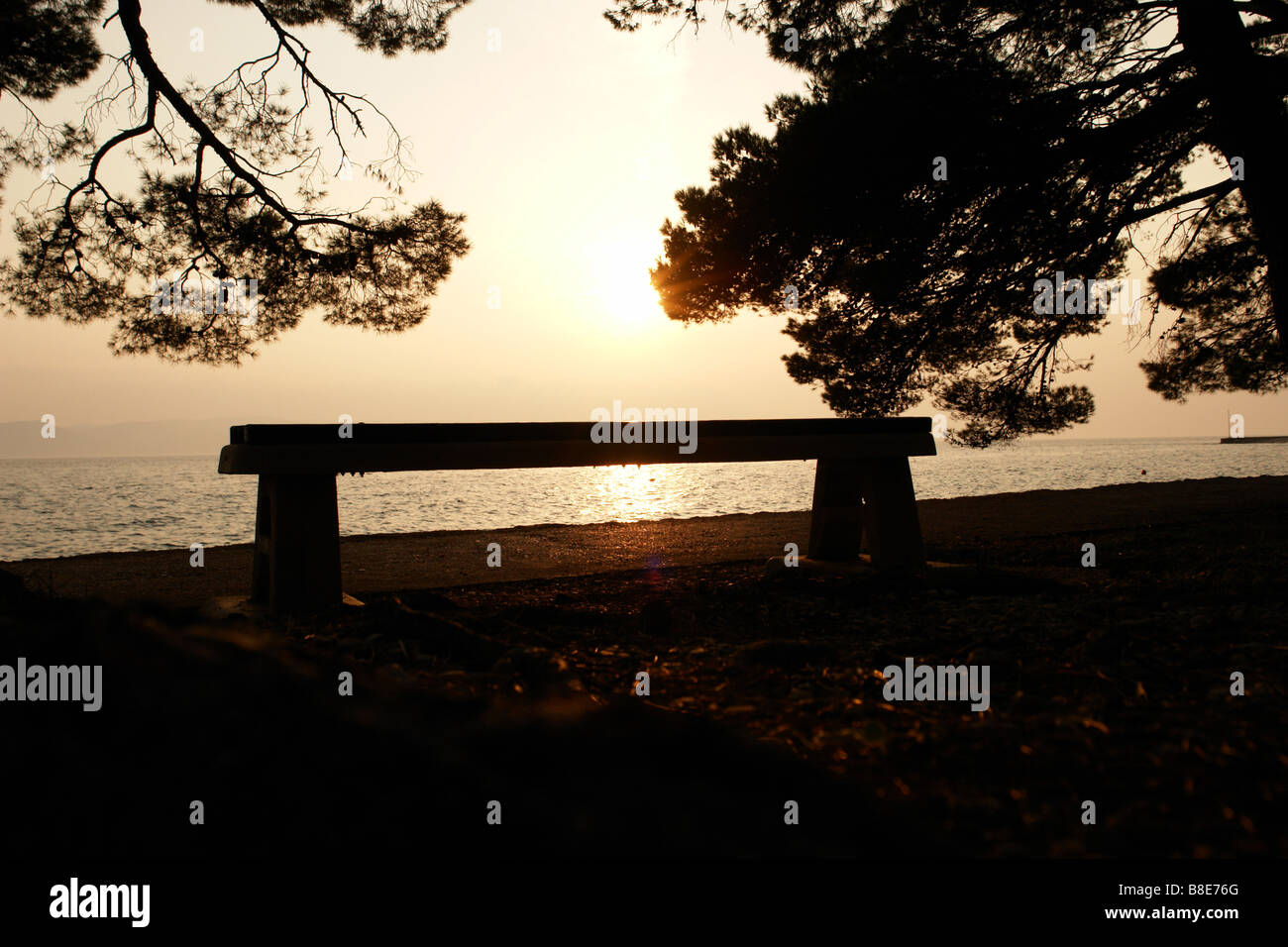 a bench at the sea at sunset Stock Photo - Alamy