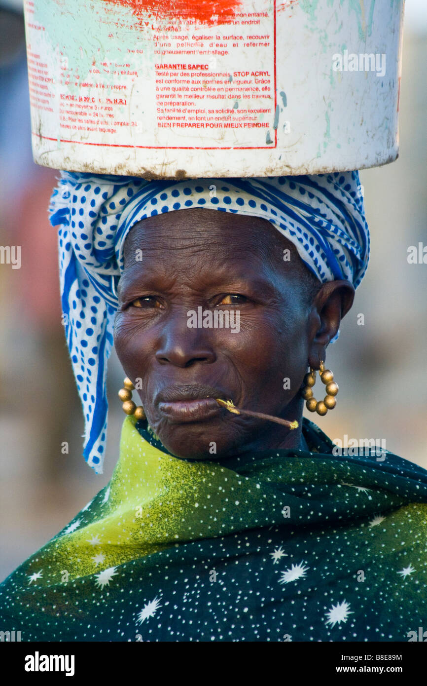 Senegalese Woman Carrying Dried Fish on her Head and Chewing on Stick ...