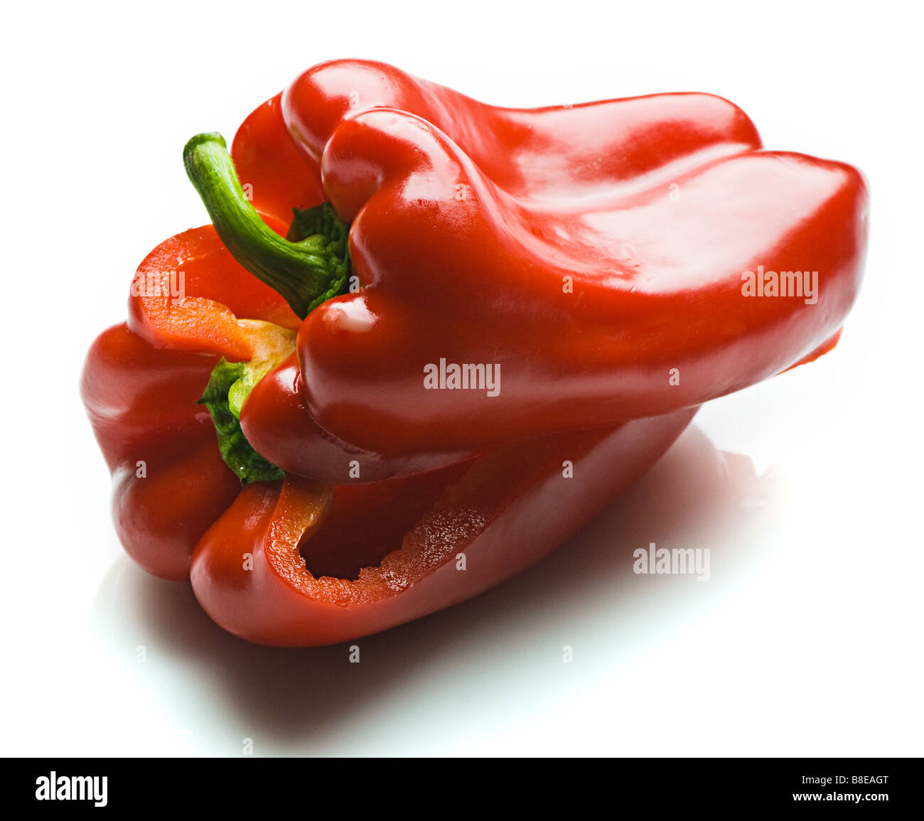 A red capsicum sliced in half and piled on each other Isolated on white ...