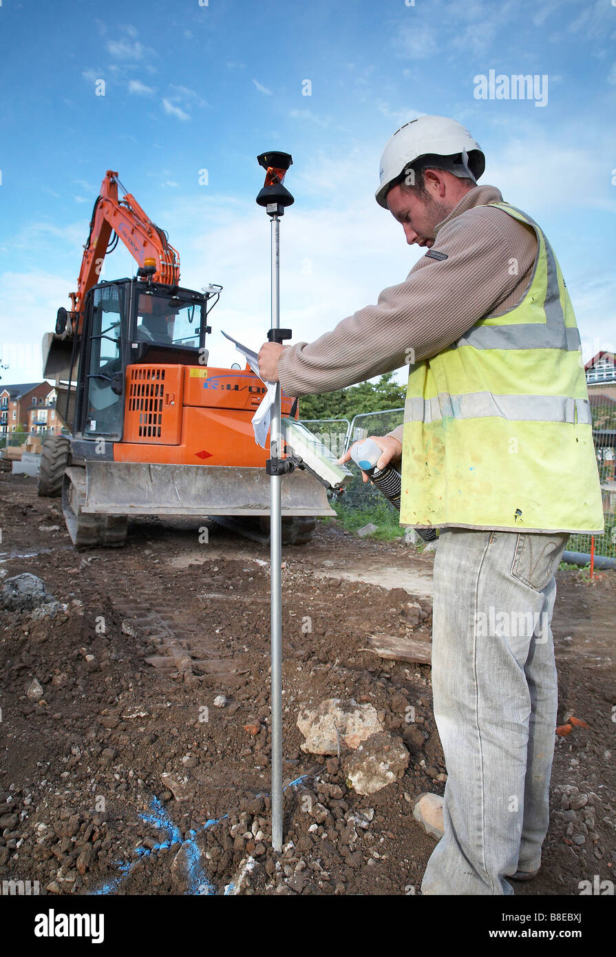 Workman Taking measurements at building site Stock Photo - Alamy