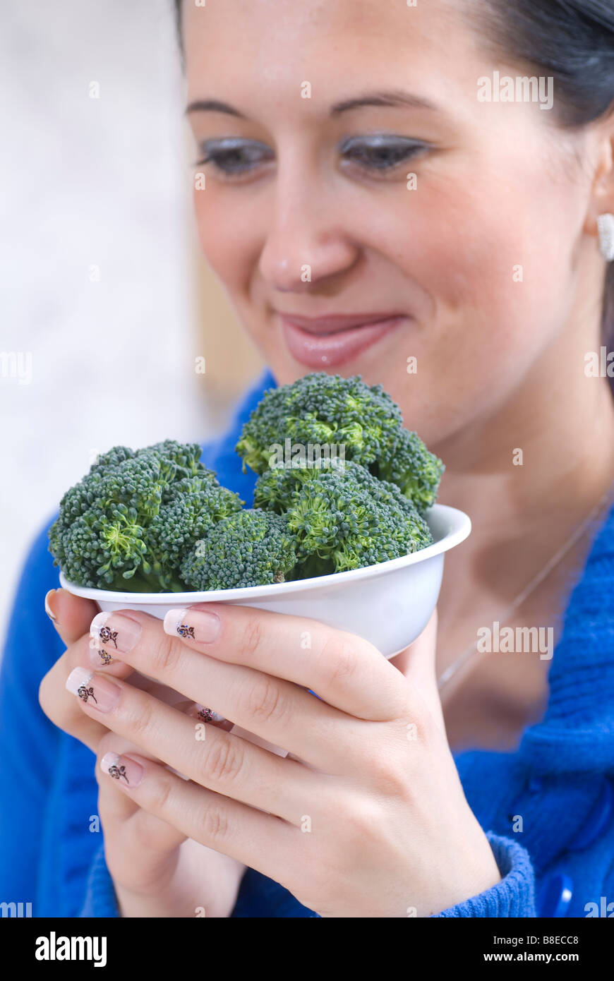 Woman holding a bowl of green broccoli Stock Photo - Alamy