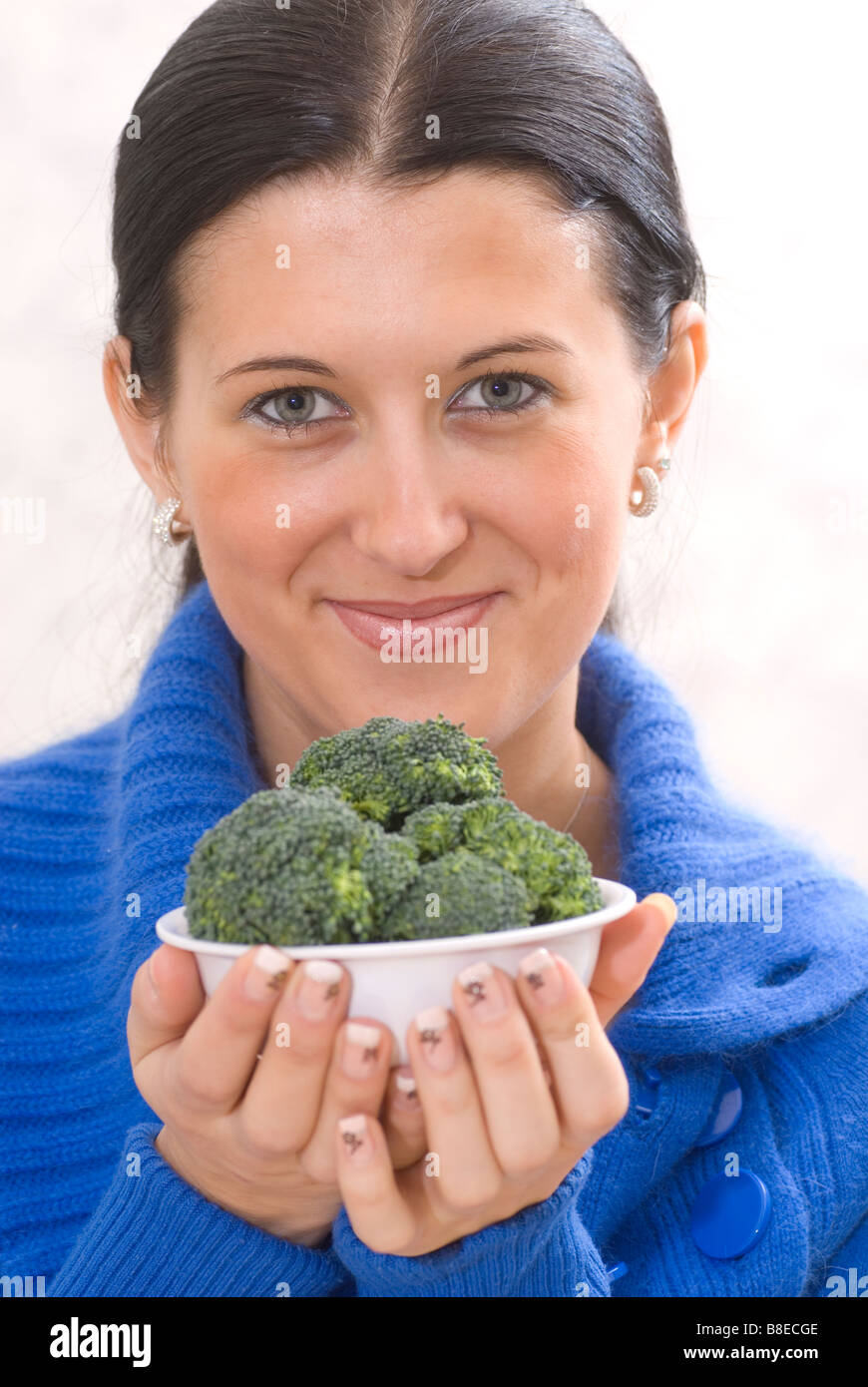 Woman holding a bowl of broccoli vegetables Stock Photo - Alamy