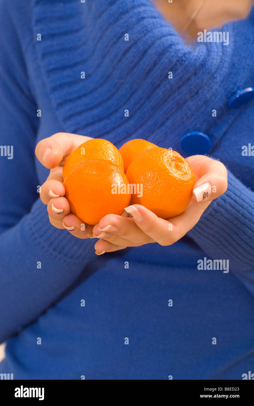 Close up of woman's hands holding mandarin fruits Stock Photo - Alamy