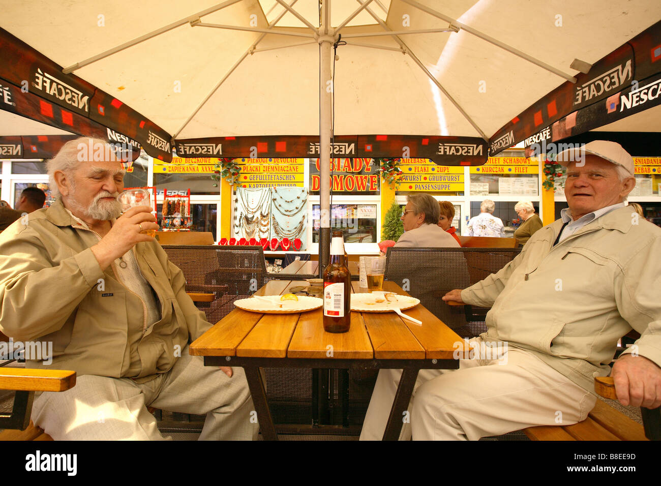 Old men eating at a street restaurant, Swinoujscie, Poland Stock Photo ...