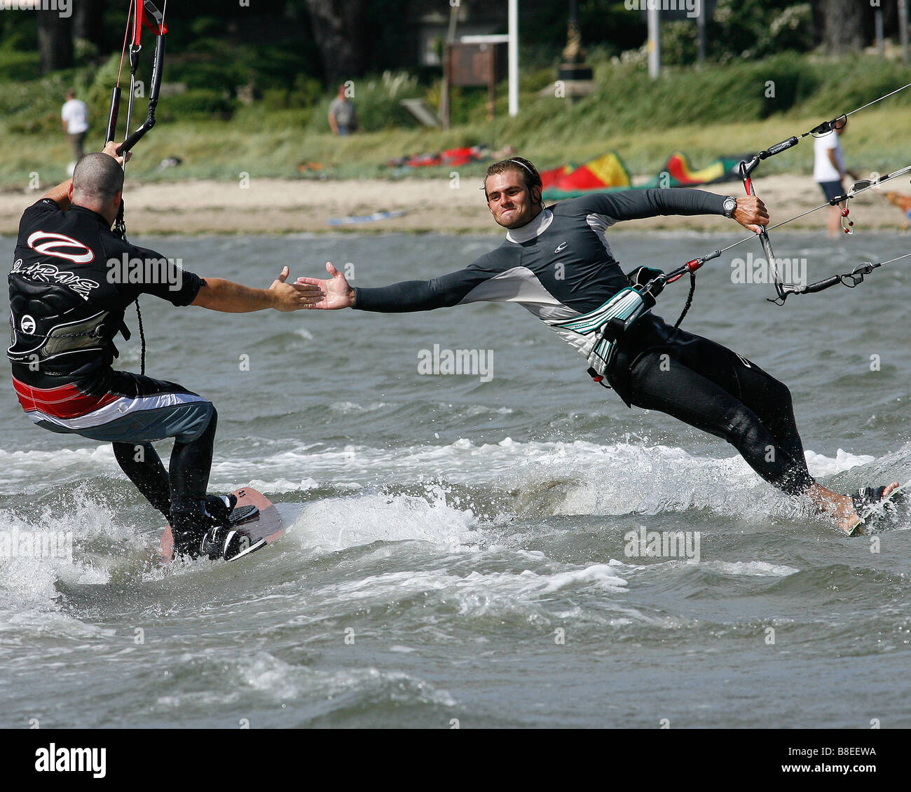 Two kitesurfing friends greeting each other Stock Photo - Alamy